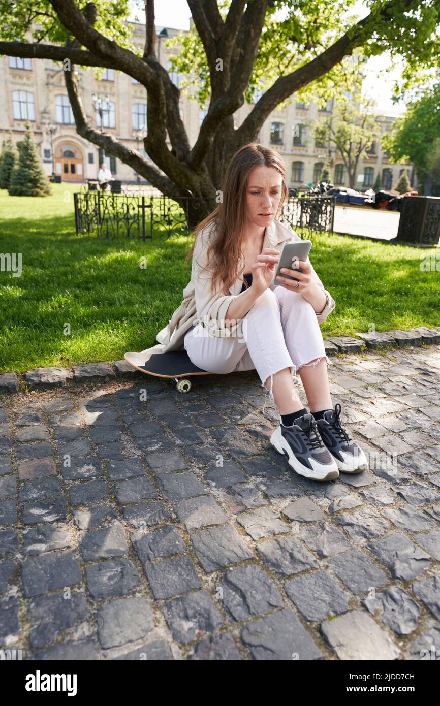 Woman skateboard uses mobile phone hi-res stock photography and images ...