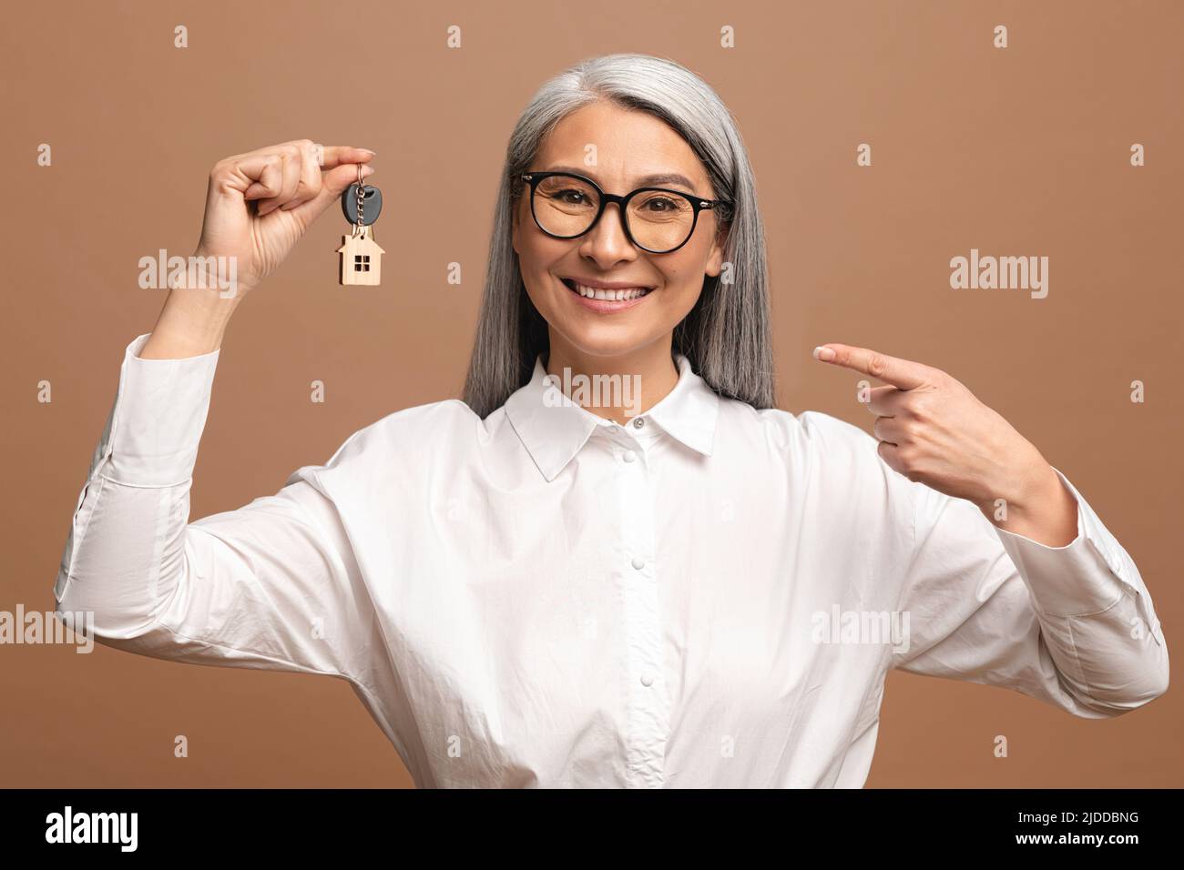 Happy overjoyed senior woman holding keys with keychain in form of ...