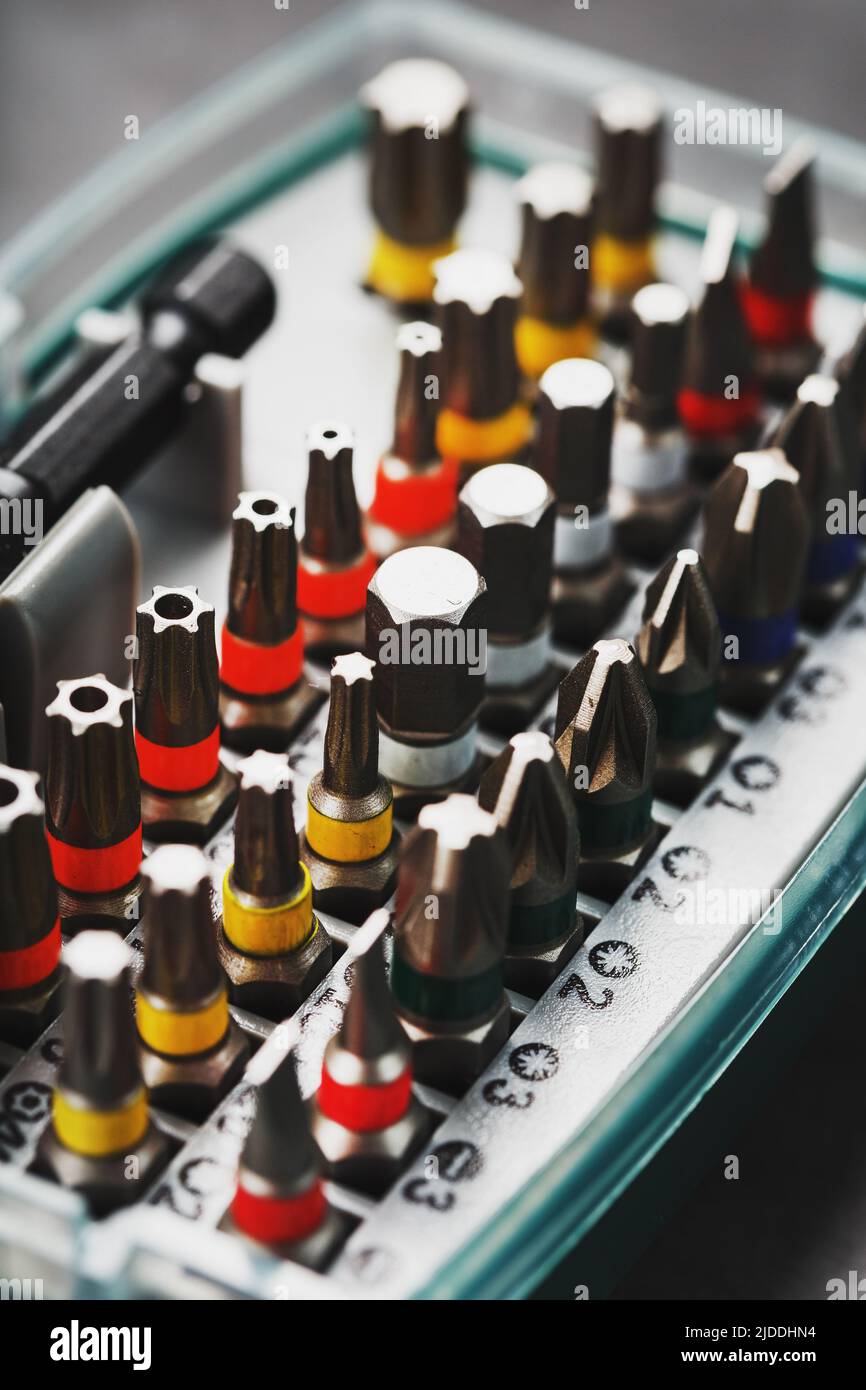 A set of metal power bits in a box on a gray background, for repair and ...