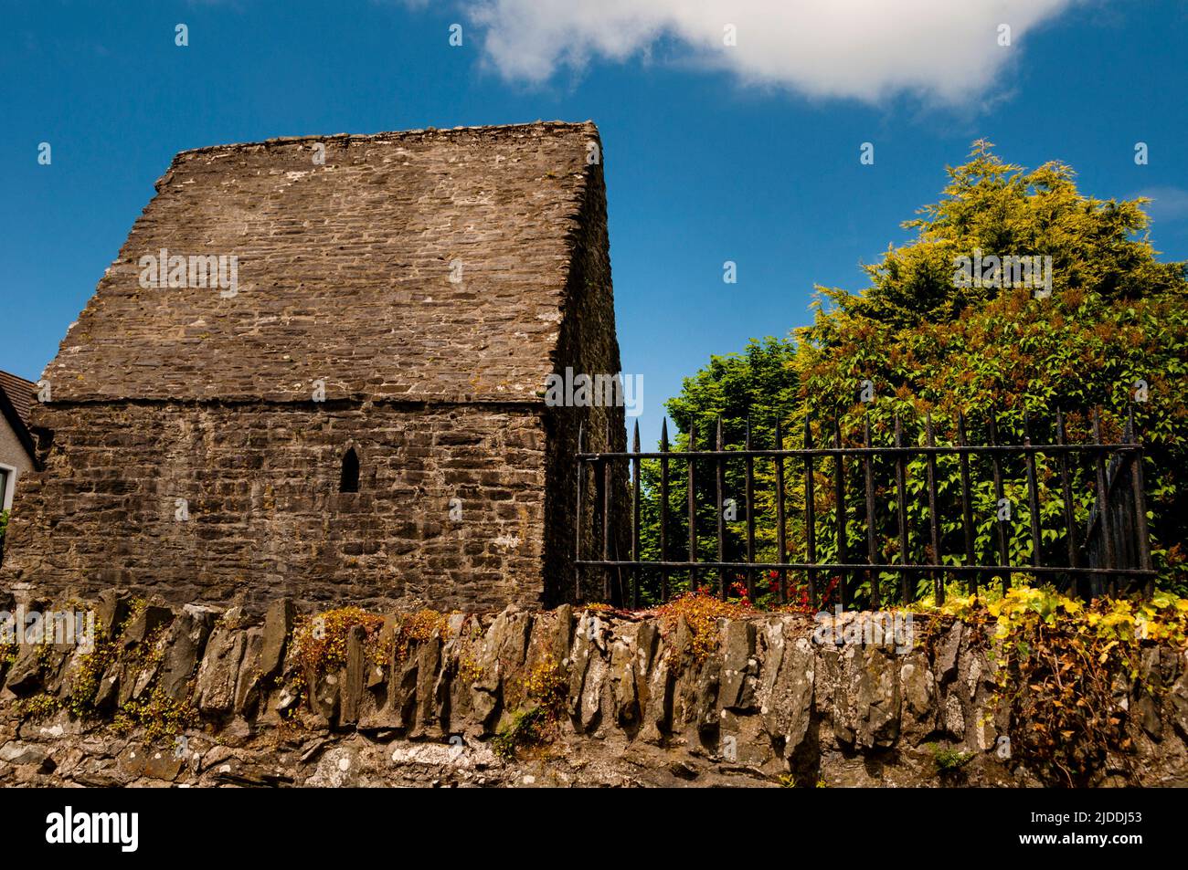 Tiny pointed arch window and steep stone gabled roof of St. Colmcilles ...