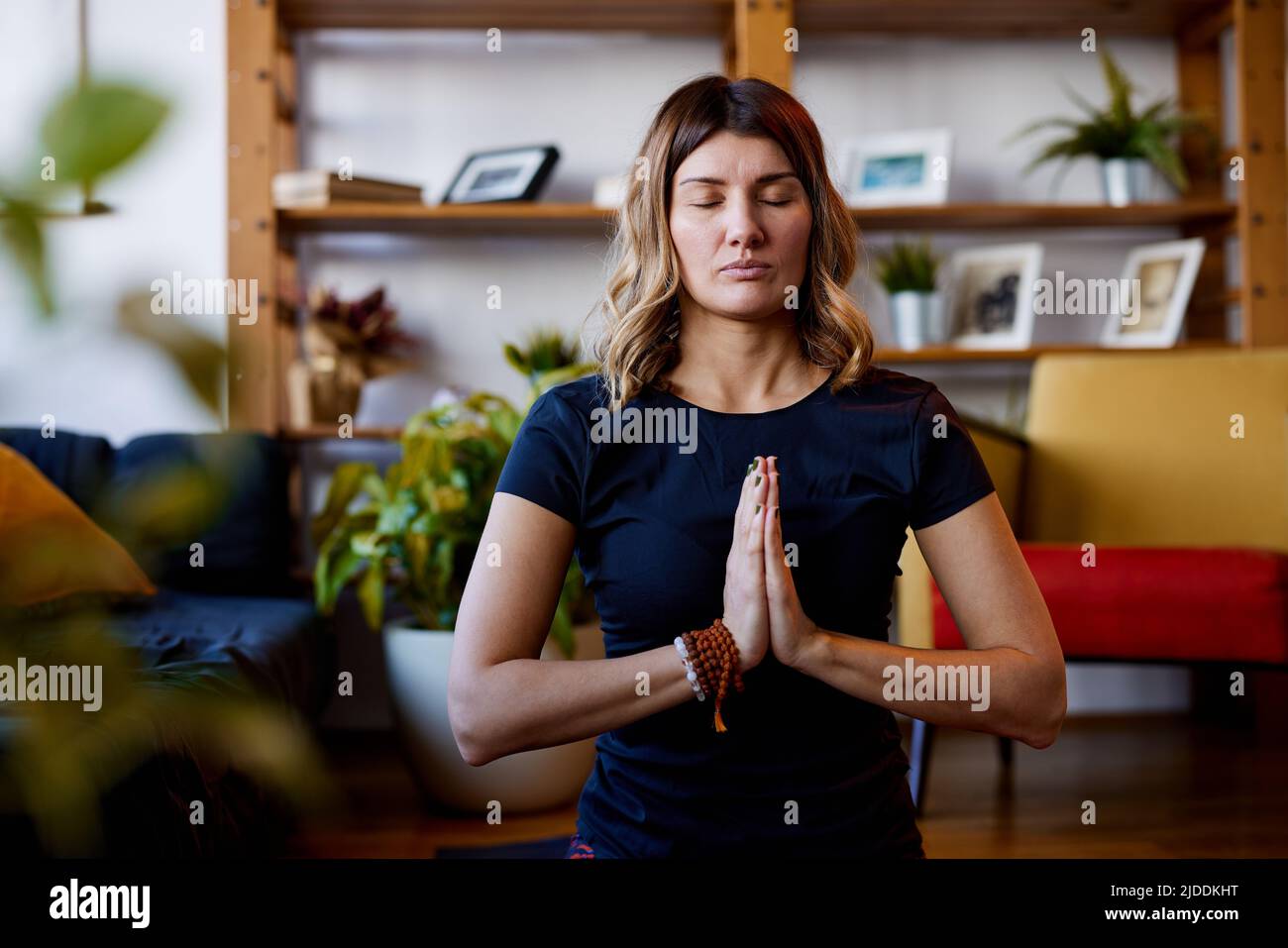 A yogi woman sitting at home with eyes closed and meditating Stock ...