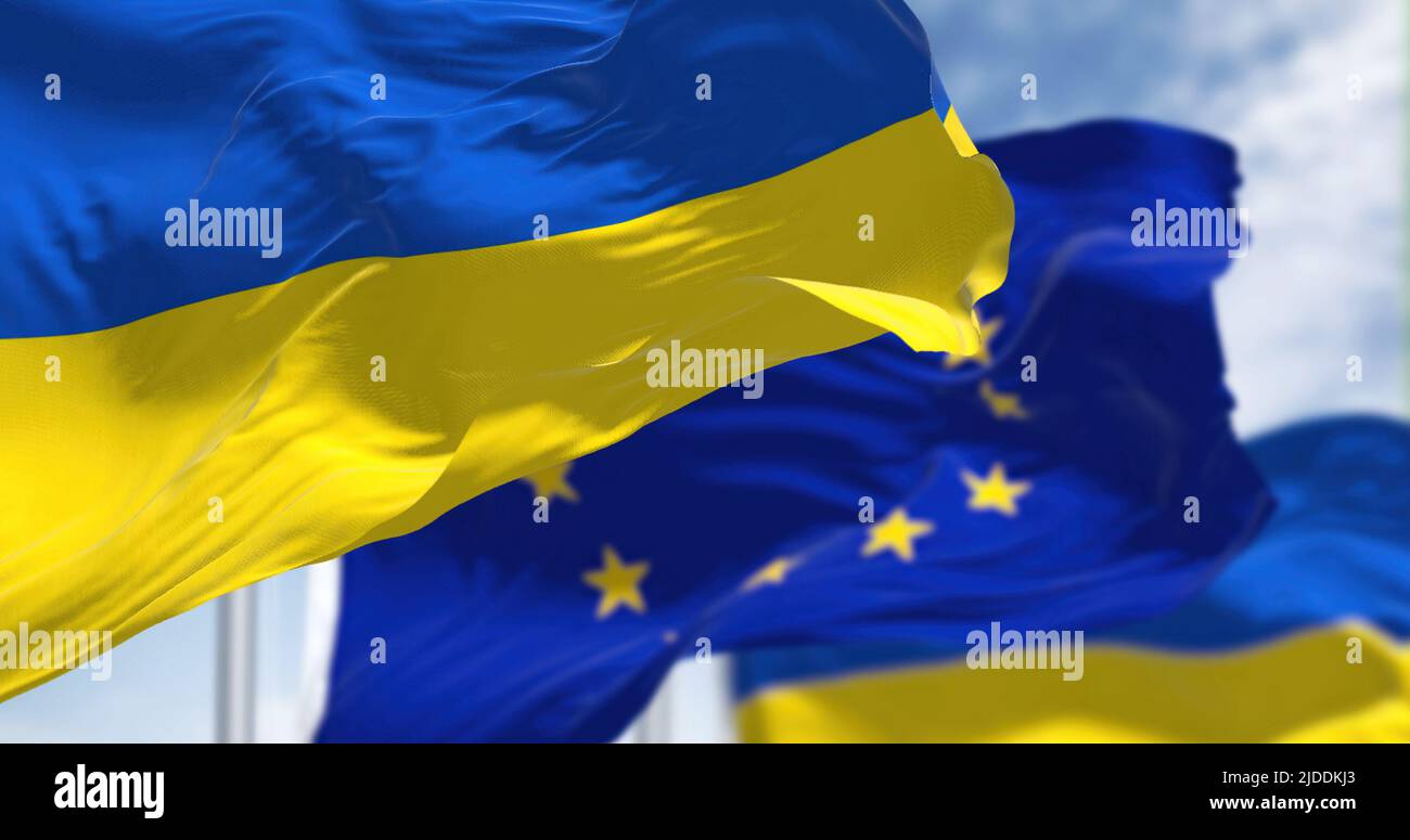 the national flag of Ukraine waving with blurred european union flag on ...