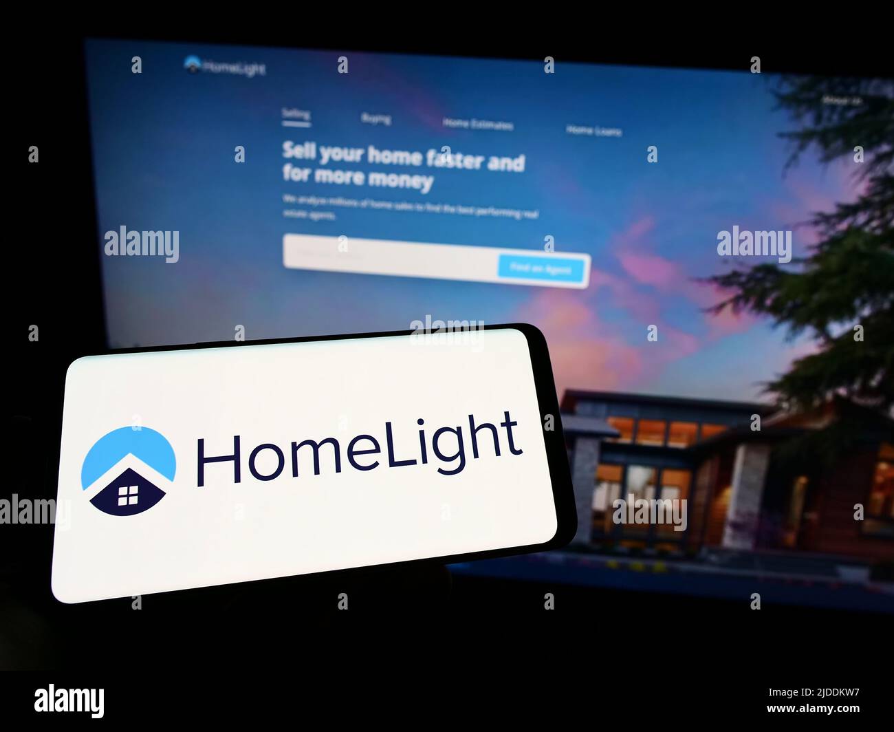 Person holding mobile phone with logo of American real estate company ...