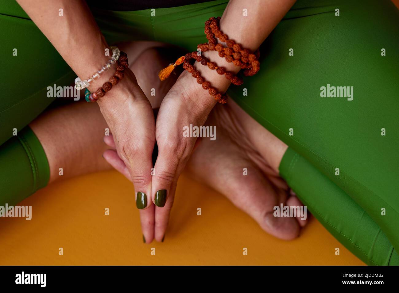 Close up of a yogi woman sitting on the yoga mat at home in a lotus ...