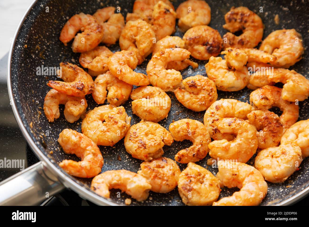 Cooking shrimps on a frypan, low angle view. Close-up Stock Photo - Alamy