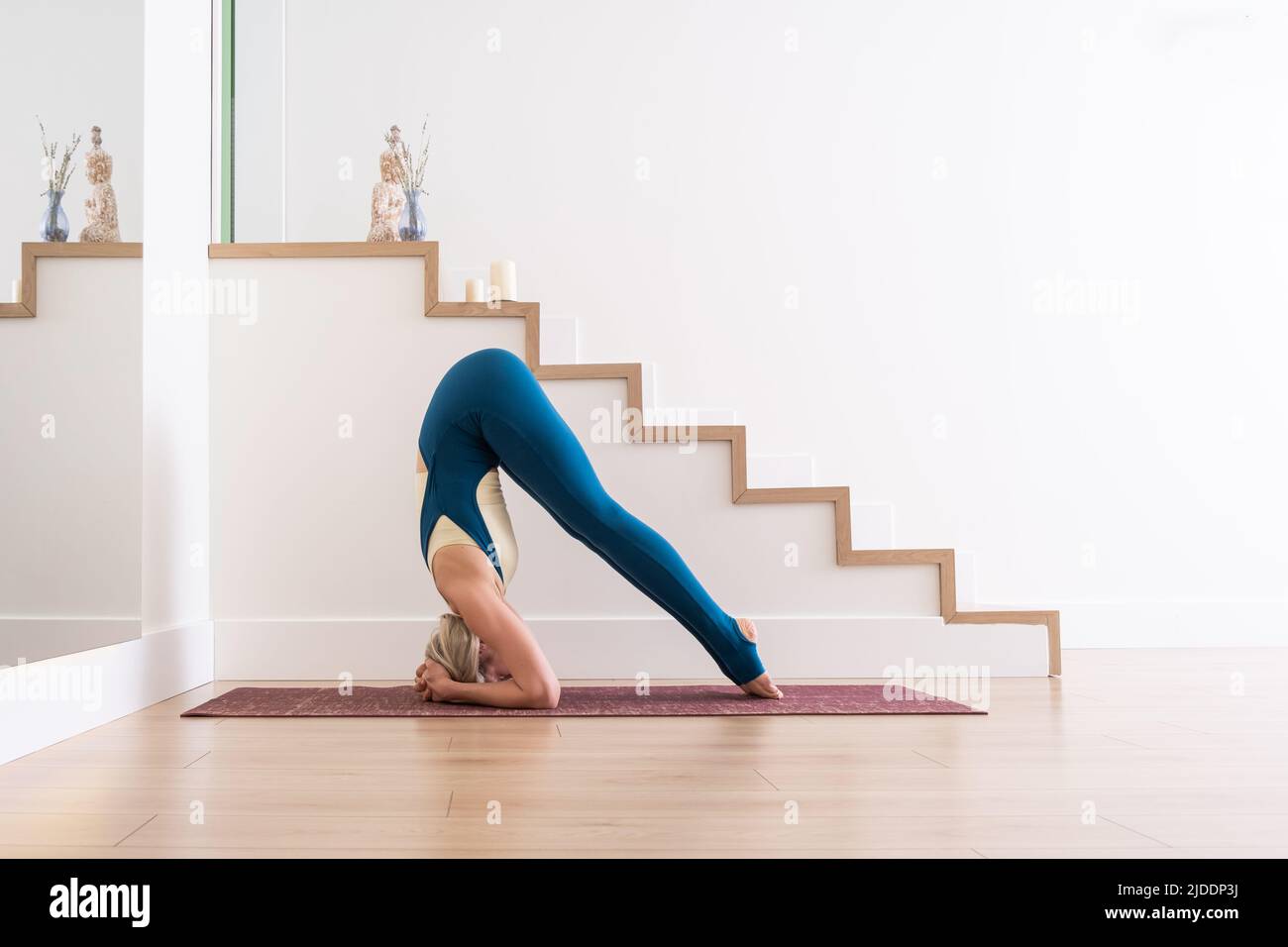 young woman practicing yoga poses stretching in white studio Stock ...