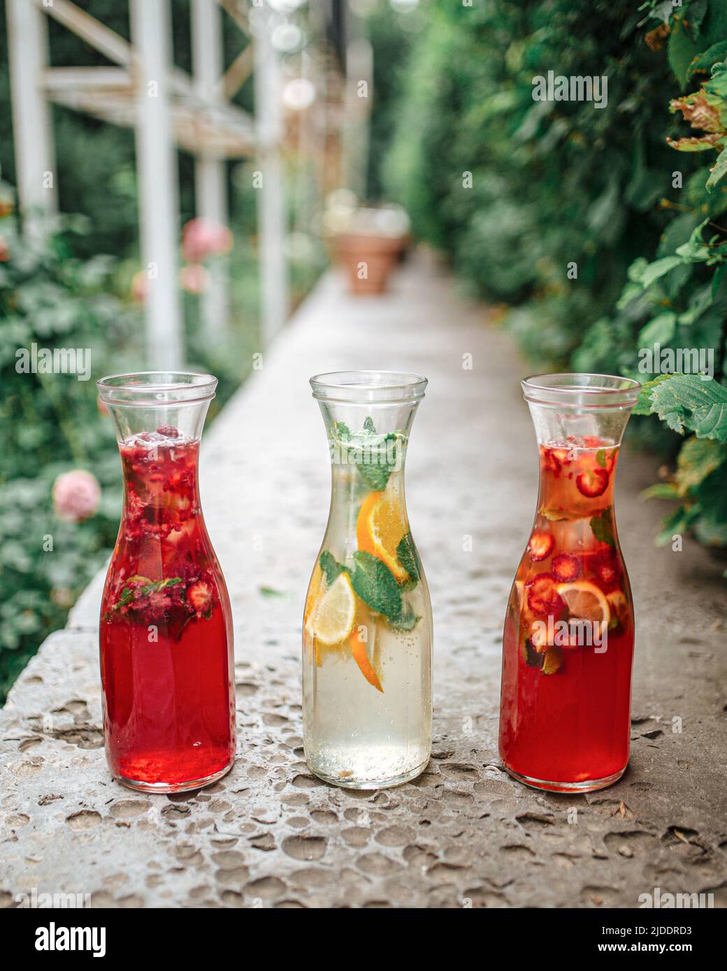 Three glass jugs of fresh berry and fruit lemonade Stock Photo - Alamy