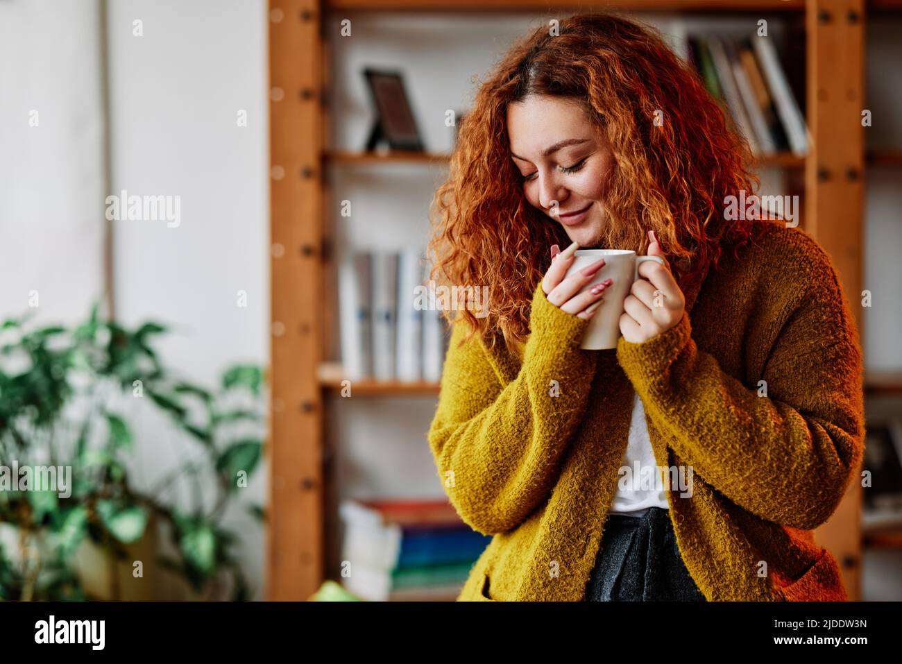 Portrait of a ginger girl holds a mug with morning coffee and sentence ...