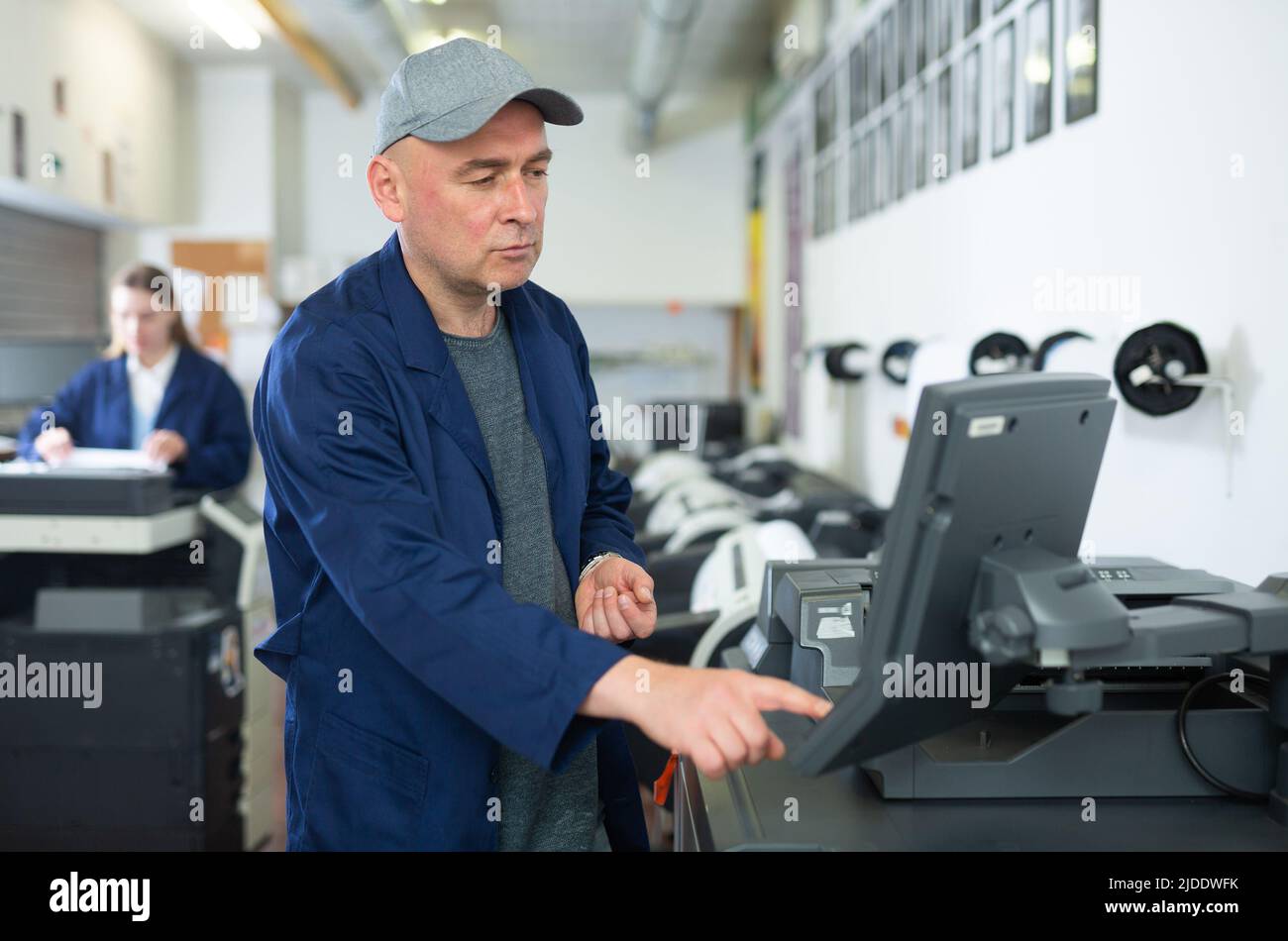 Man using printer while working in print shop Stock Photo - Alamy