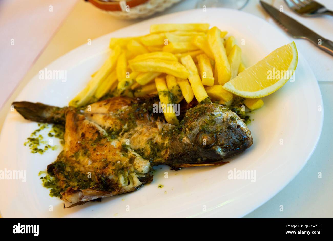 Baked in oven dorado fish with potatoes served with lemon Stock Photo ...