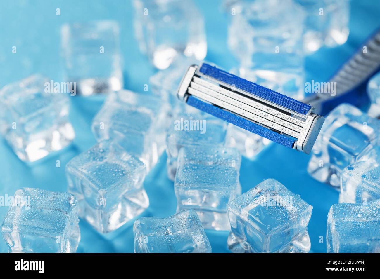 Shaving machine on a blue background with ice cubes. The concept of ...