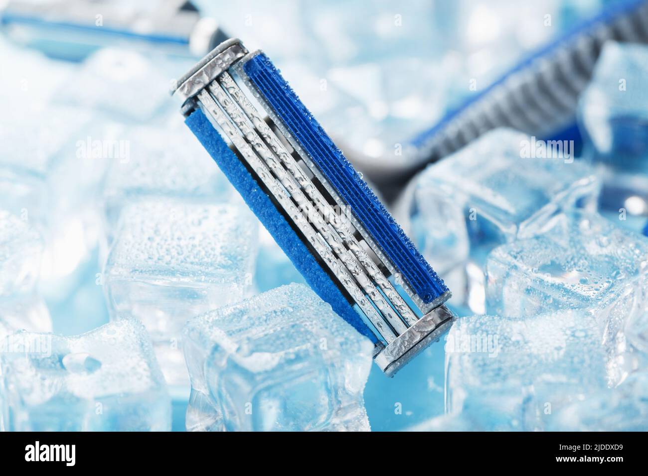 Shaving machine on a blue background with ice cubes. The concept of ...