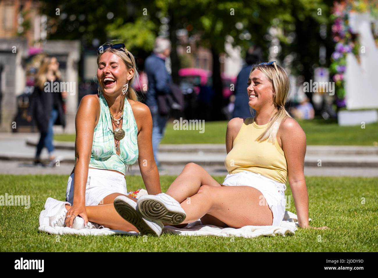 Anna Harper (left) and Leah Burdett enjoy the hot weather outside Belfast City Hall. Picture ...