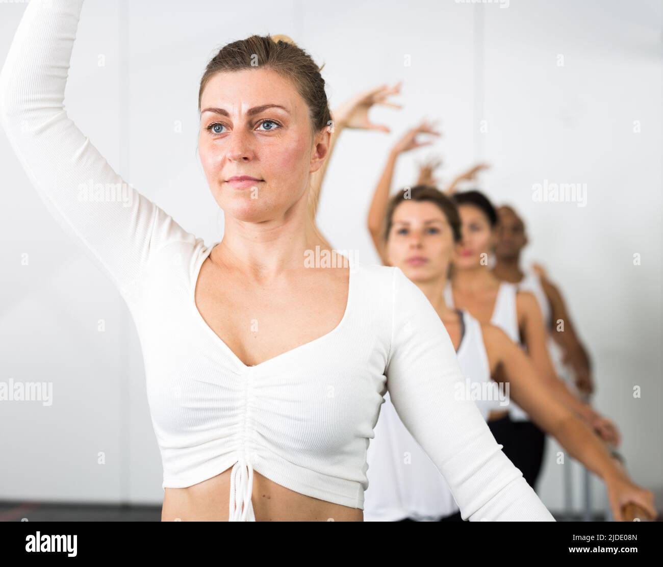 Closeup of group of women and men with their hands up during ballet ...