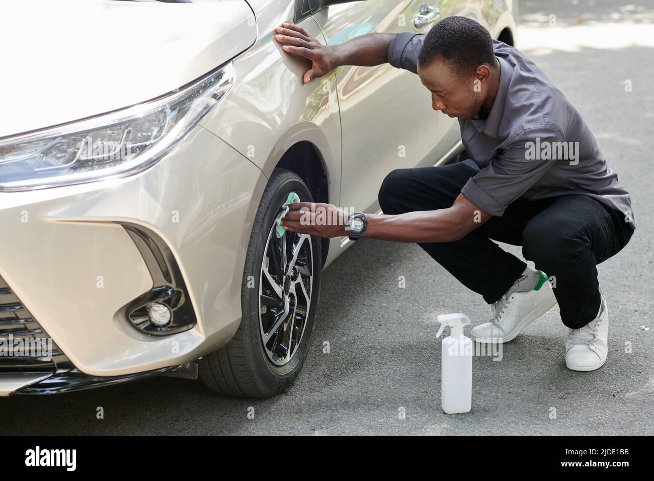 Car owner cleaning alloy rim with cleaning detergent before ride Stock ...