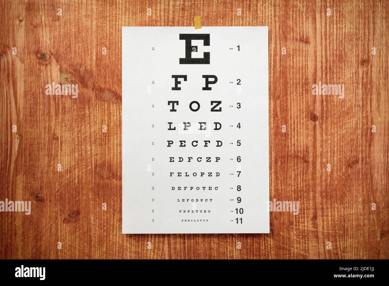 Eye test chart - white optometry chart on the wooden wall Stock Photo ...