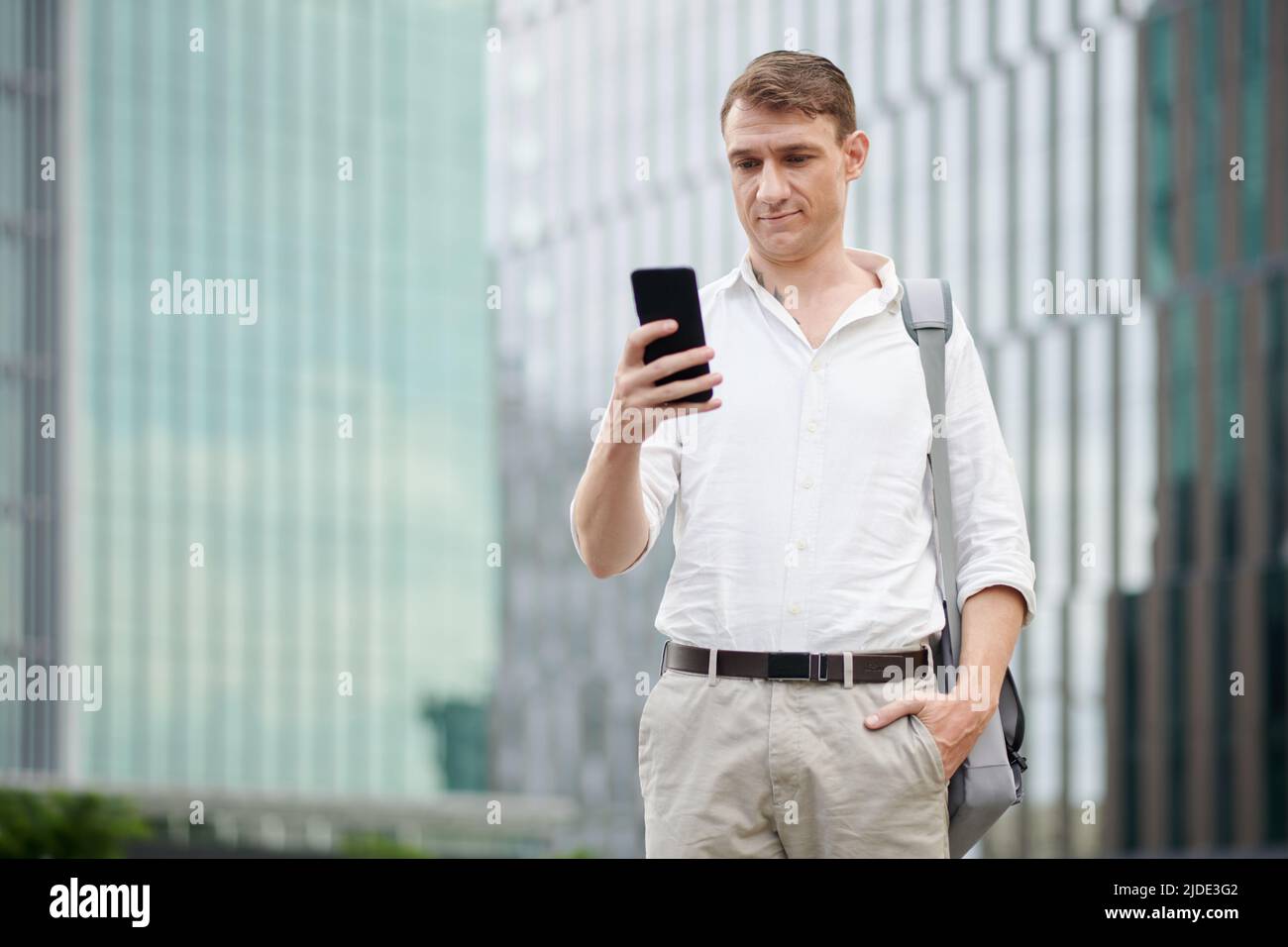 Portrait Of Confused Man Reading Text Message From Taxi Driver On