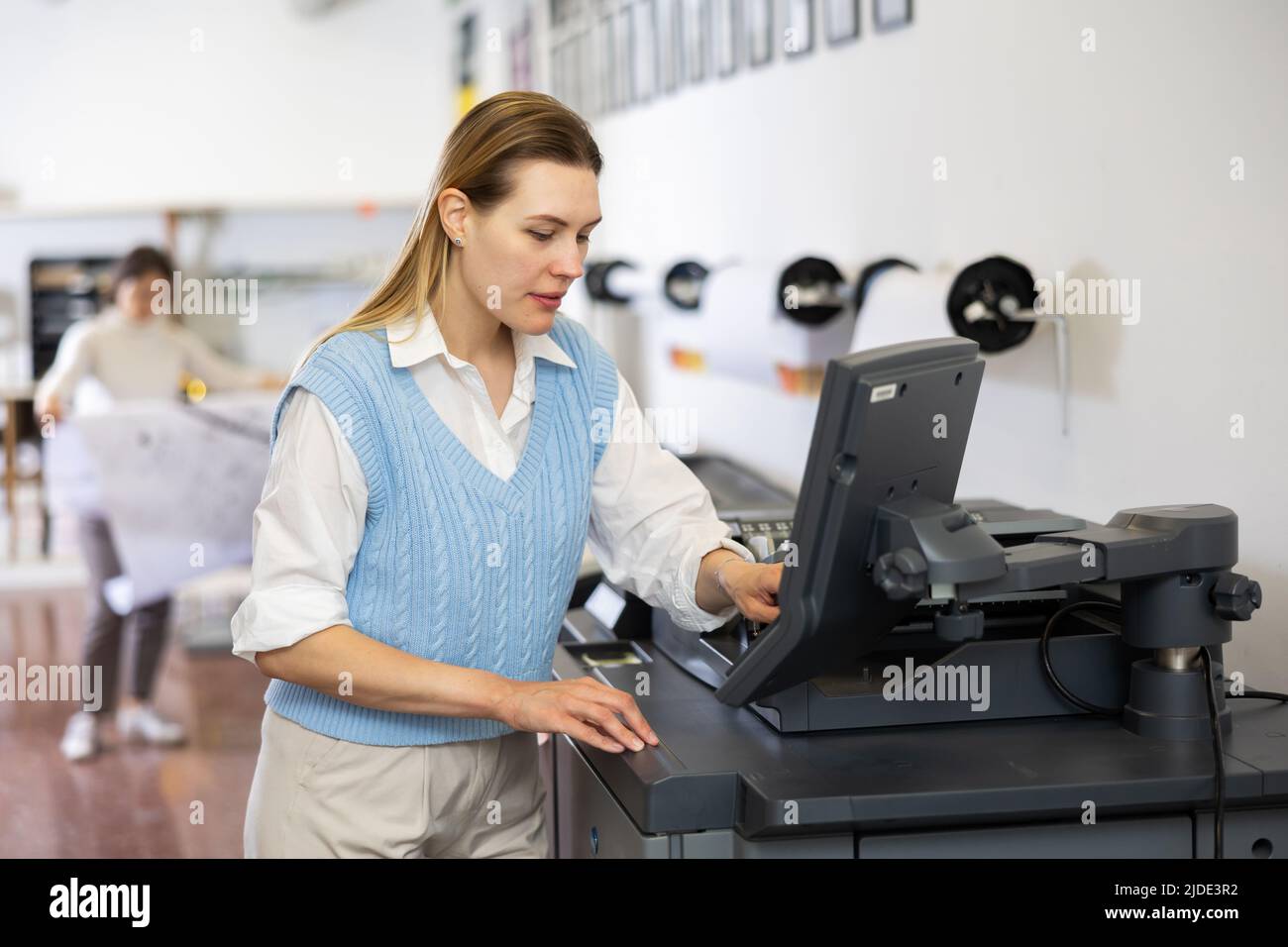 Technician operator calibrating plotter machine, typing on computer ...