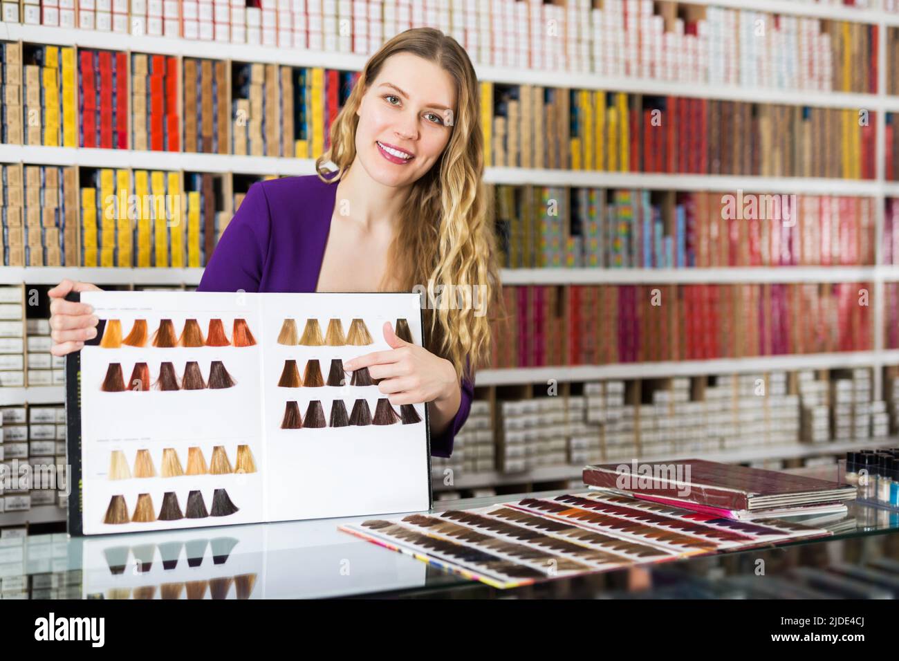 saleswoman helping to choose new hair dye for coloring Stock Photo - Alamy