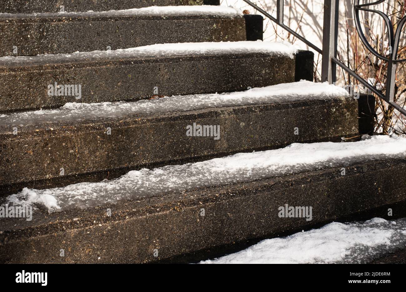 side view to stone steps of an outdoor stairway with melting snow on a ...
