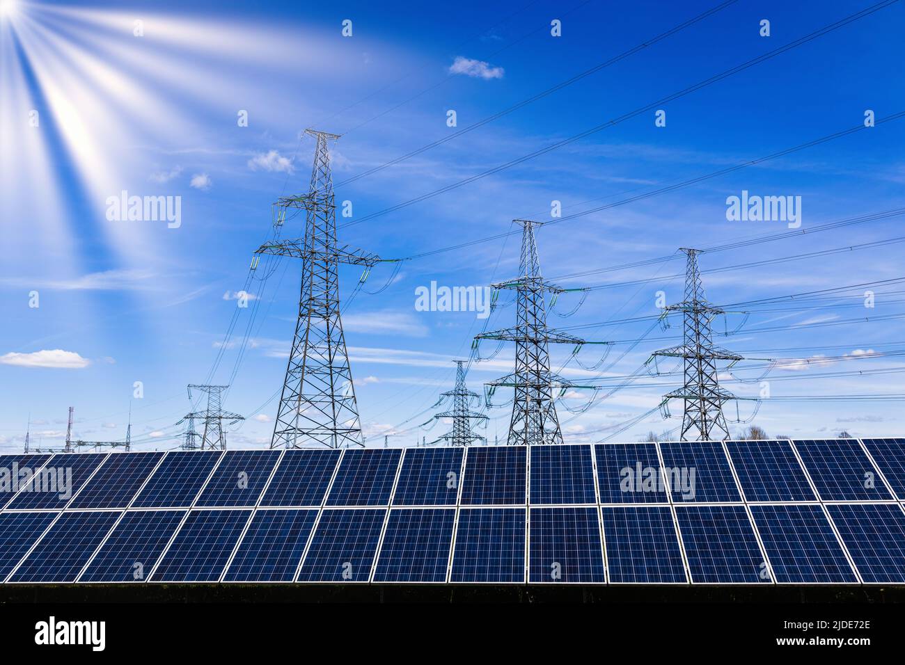 Solar panels, high voltage electricity towers, and sun rays Stock Photo ...