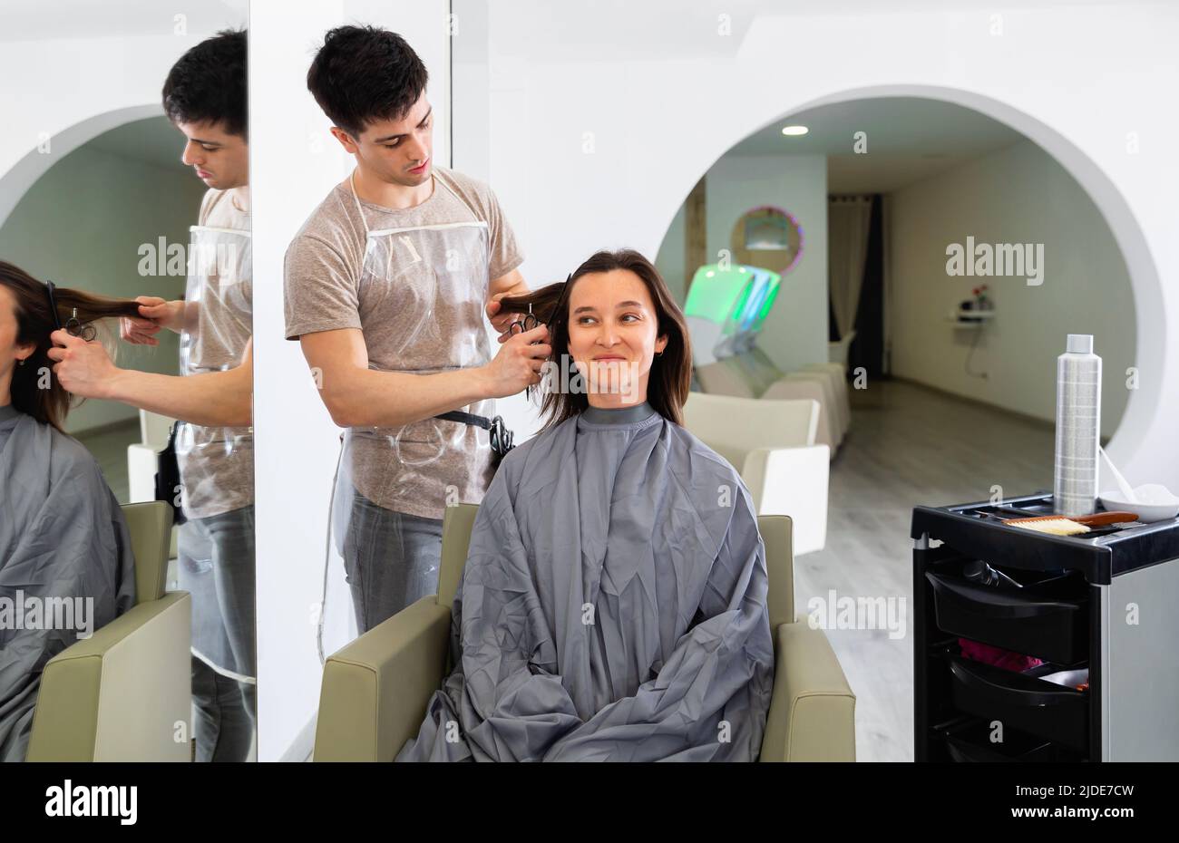 Hairdresser combing young womans hair hi-res stock photography and ...