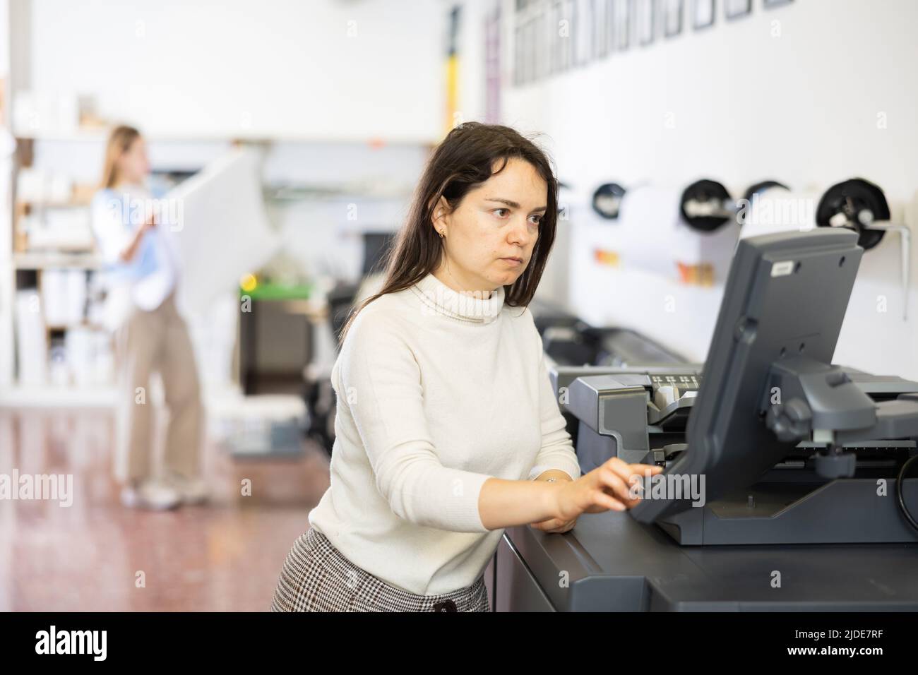 Woman working in printing office, using printer Stock Photo - Alamy