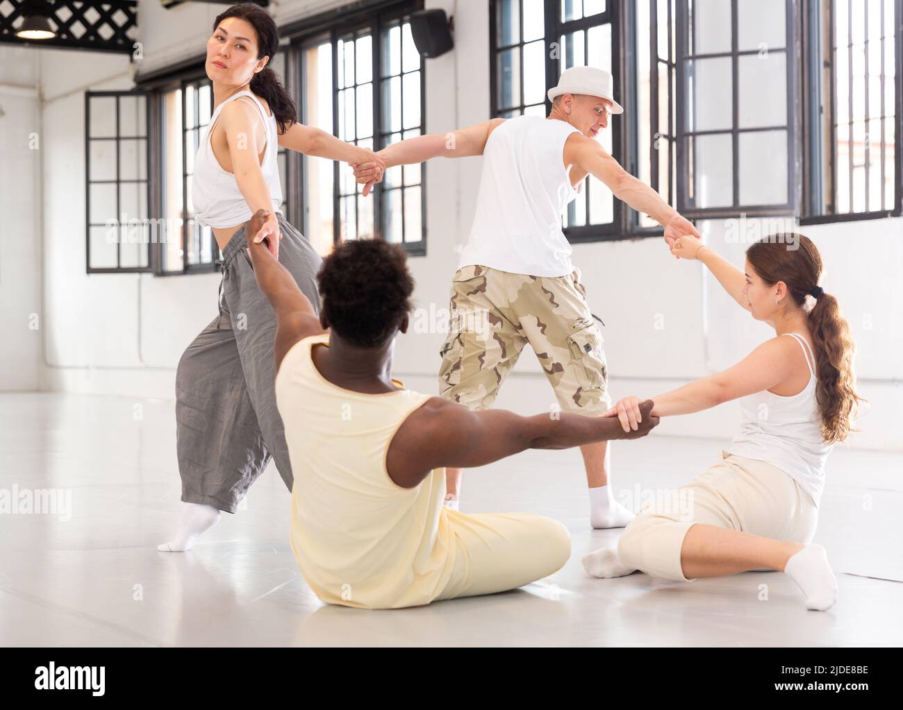 Group of young people dancers holding hands standing in circle Stock ...