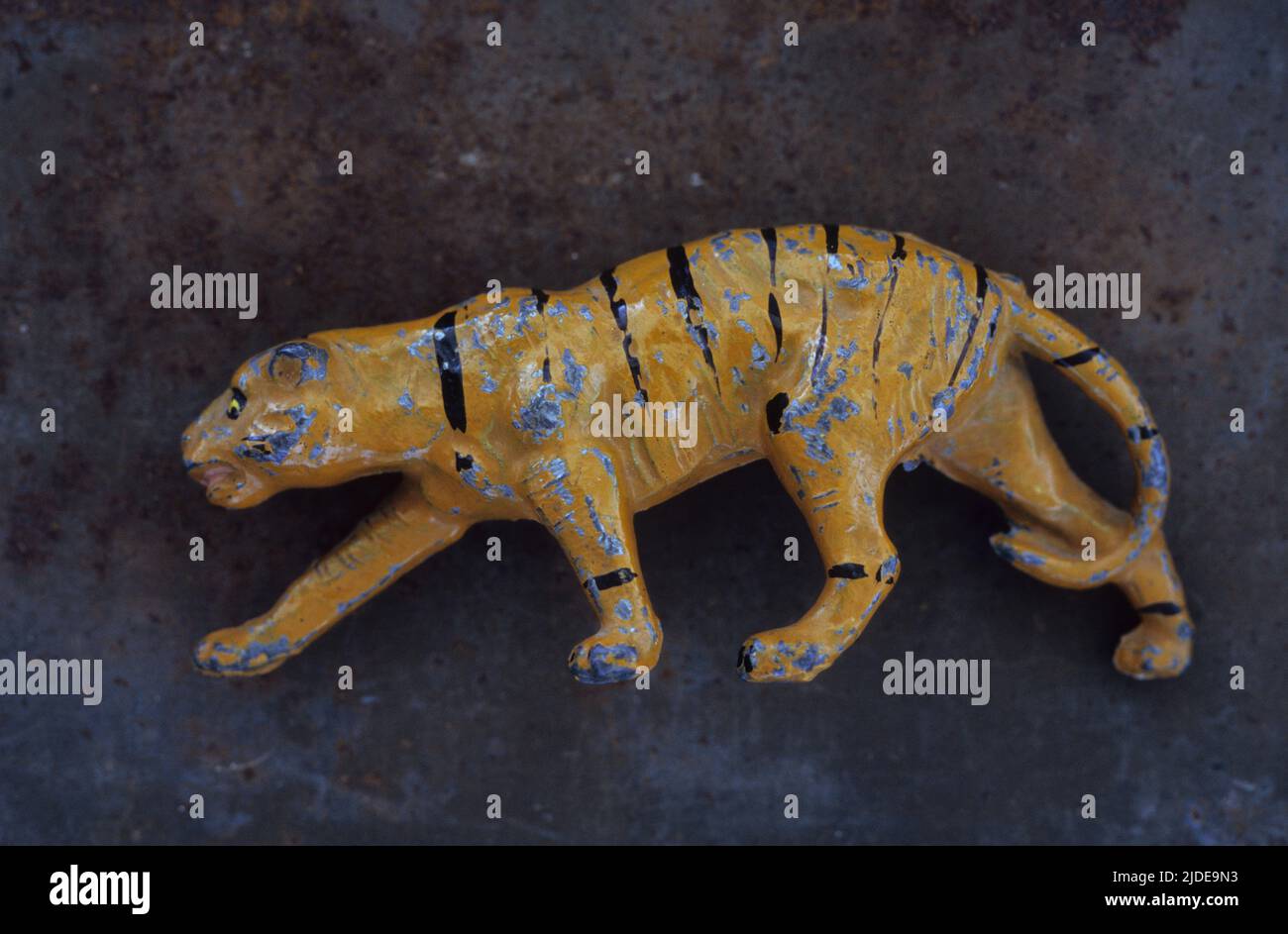 Close up of battered and scratched lead model of tiger in stalking ...