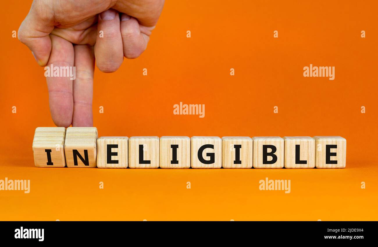 Eligible or ineligible symbol. Businessman turns wooden cubes and ...