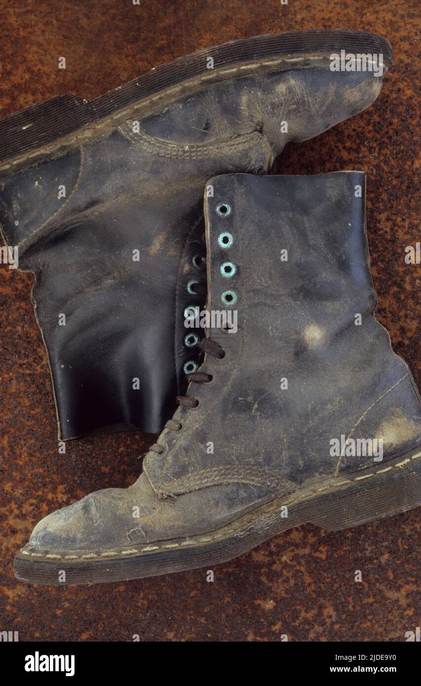 Pair of well-worn black heavy-duty industrial working boots lying on ...