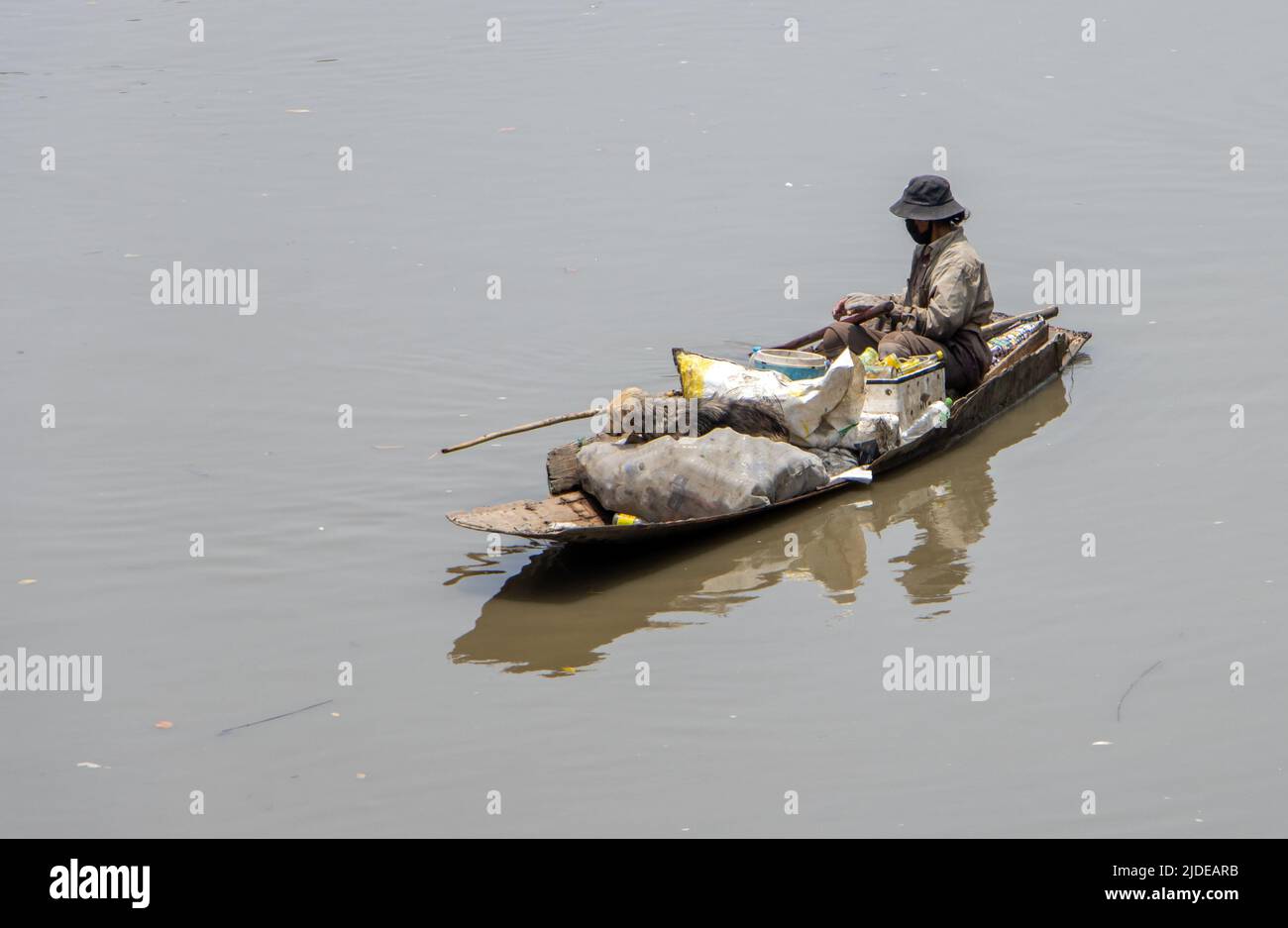 A poor human floats on an old boat full of recycled materials Stock ...