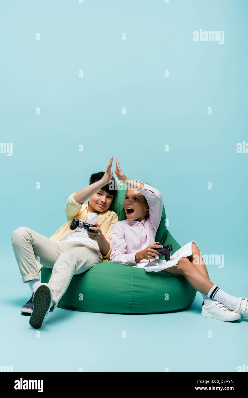 KYIV, UKRAINE - JULY 2, 2021: Multiethnic kids holding joysticks and ...