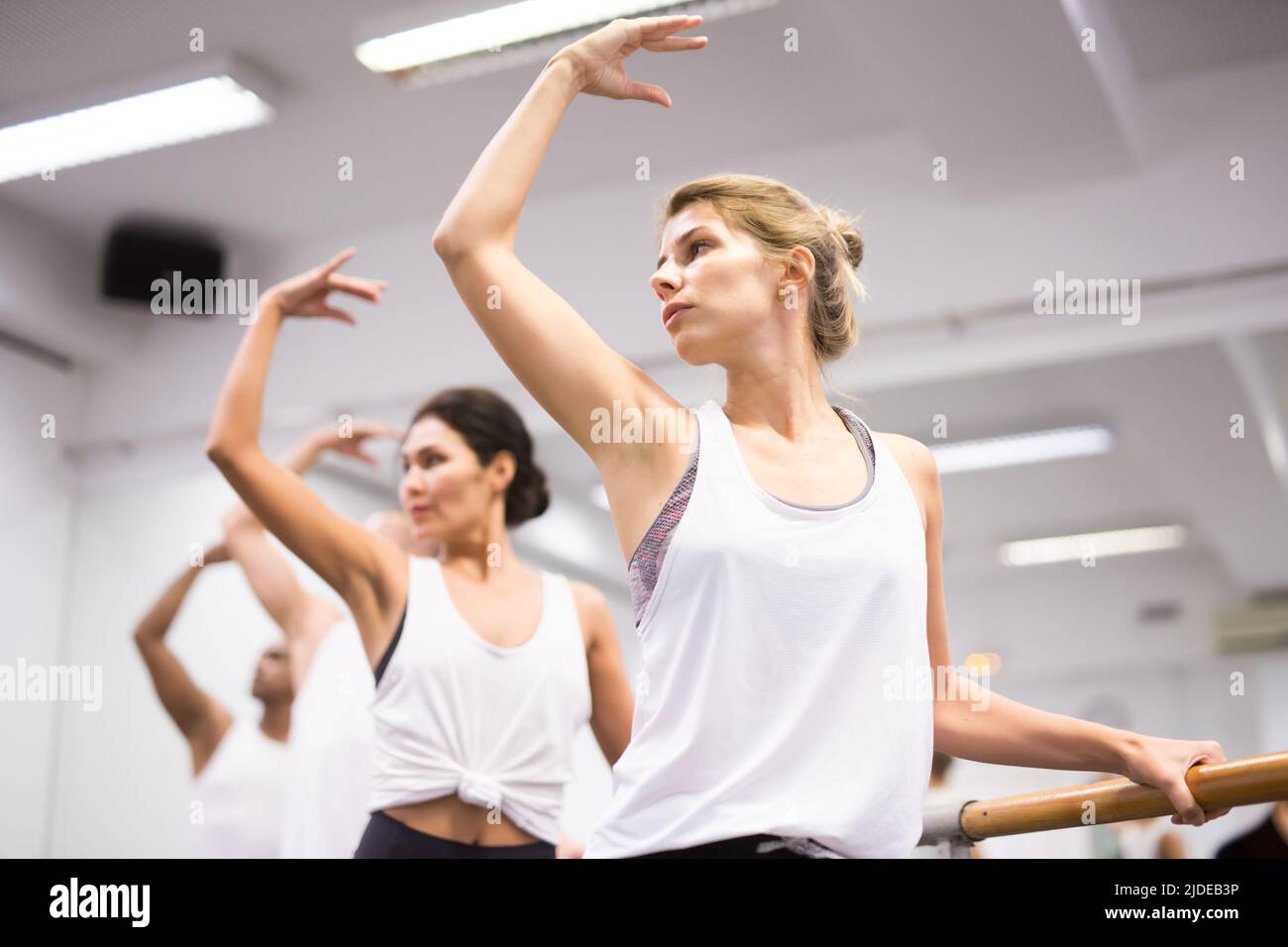 Women in ballet class, holding bar in ballet pose closeup Stock Photo ...
