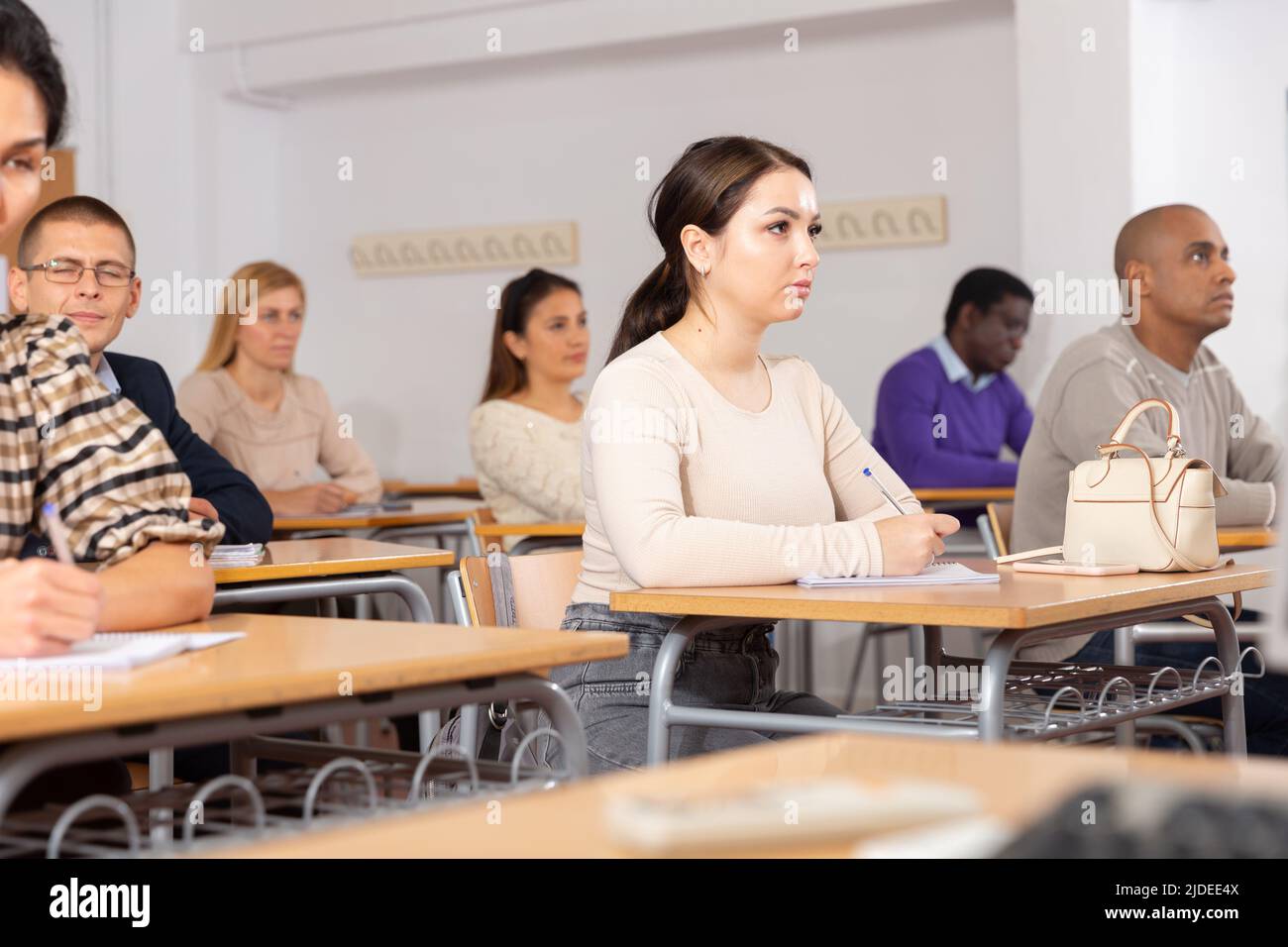 Focused young woman on lesson in school auditorium Stock Photo - Alamy