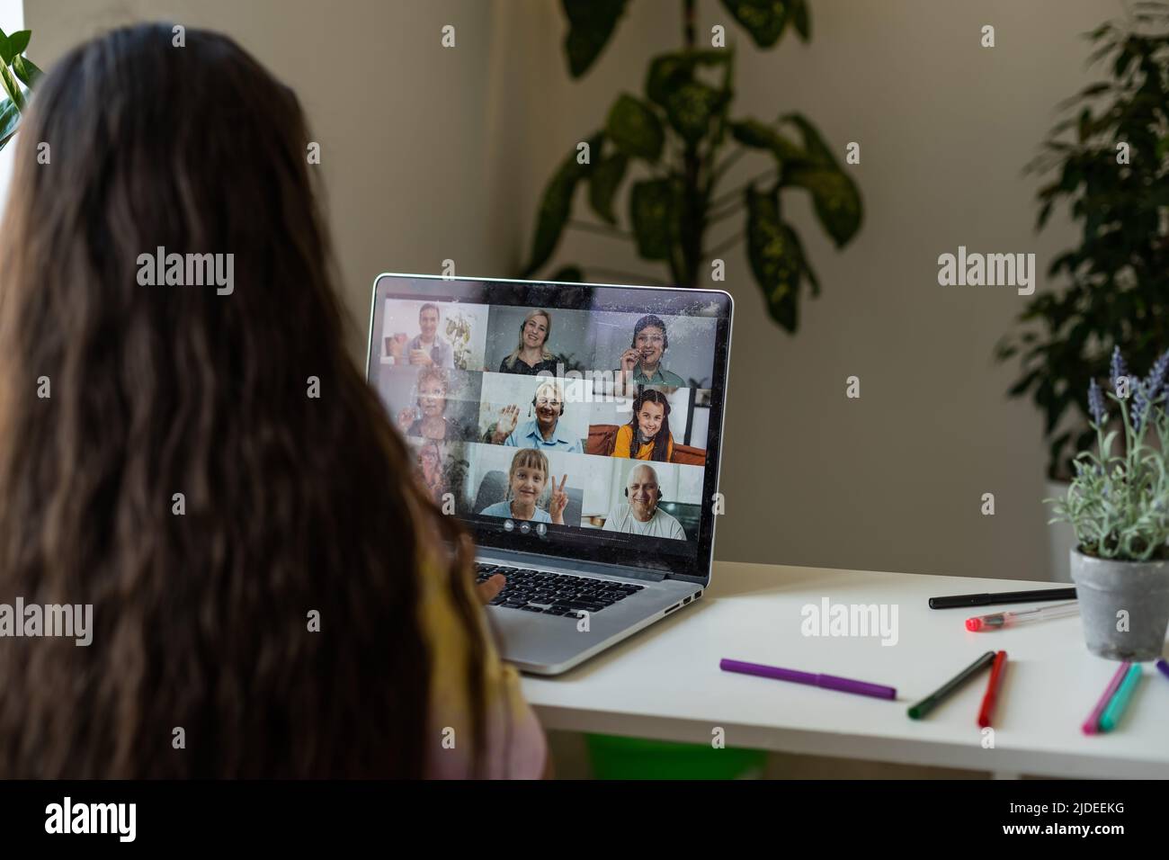 Home schooling. A girl is sitting at a table with a laptop during an ...