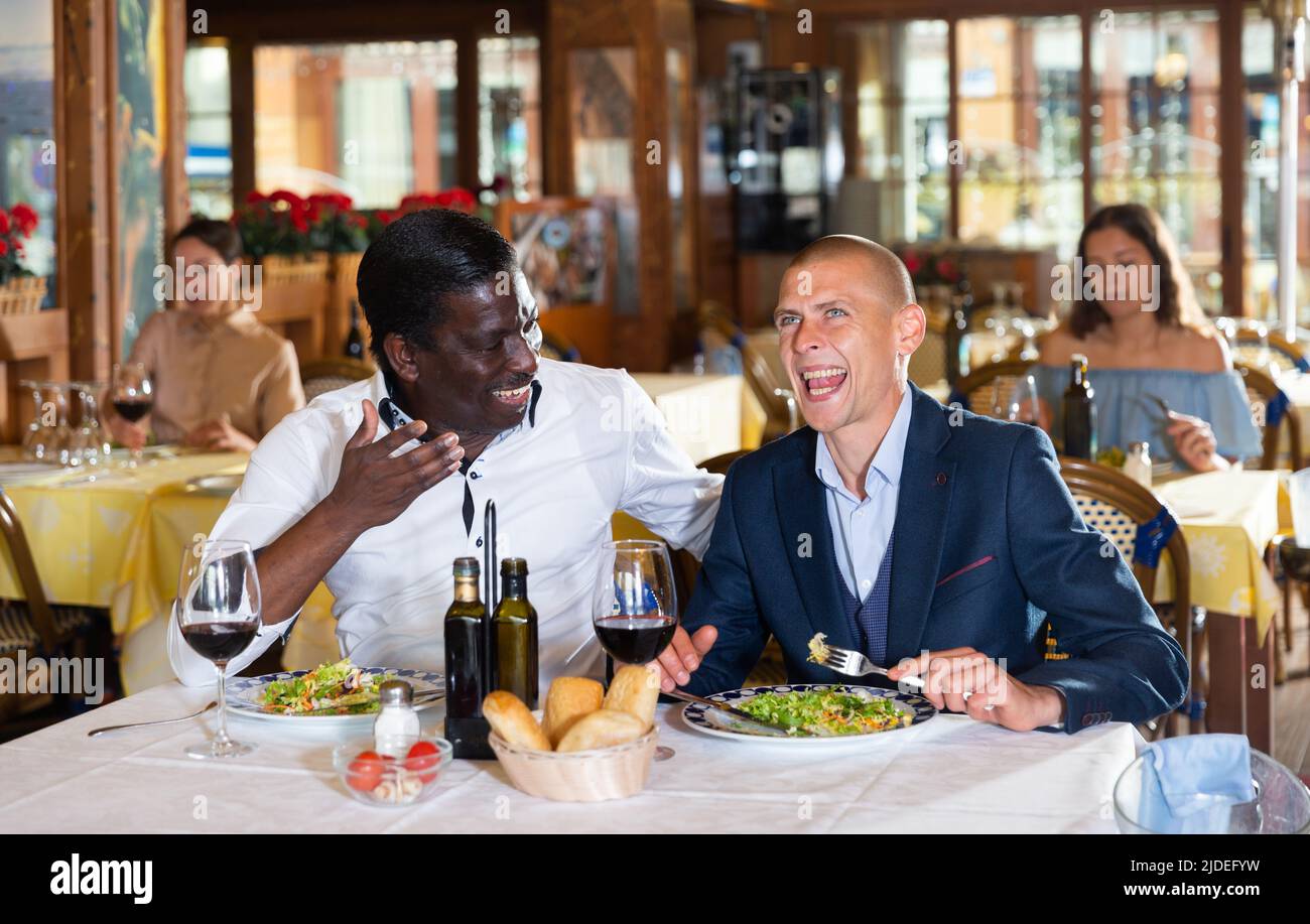 Two handsome men in classic suits having dinner at restaurant Stock ...