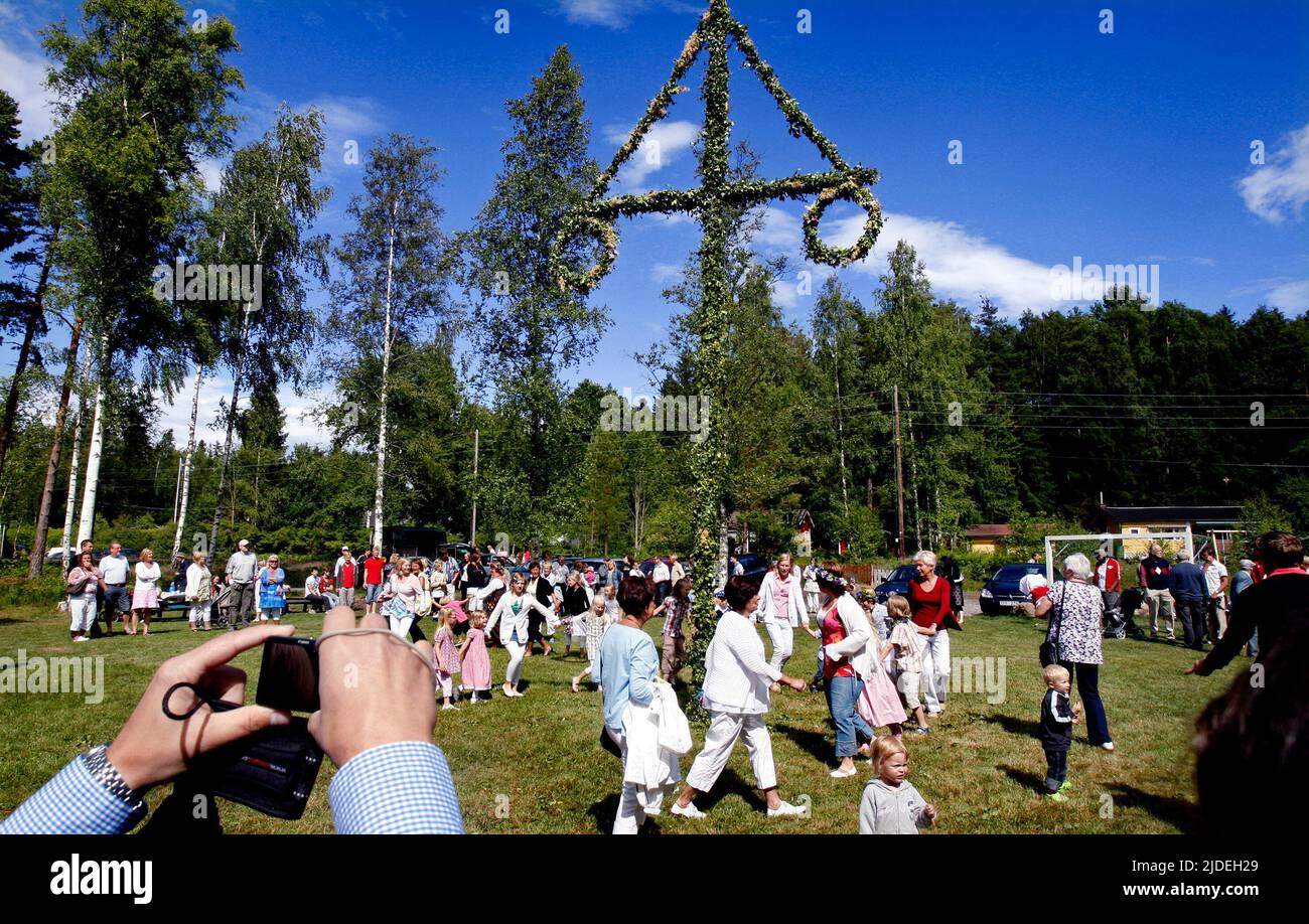 Raising and dancing around a maypole during a midsummer celebration in ...