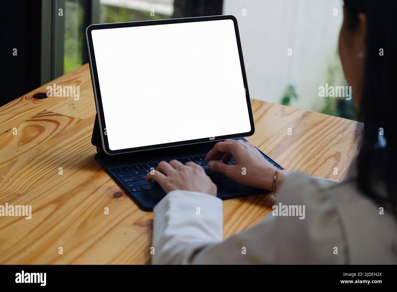 A woman using a tablet with a blank white screen. The blank space on ...