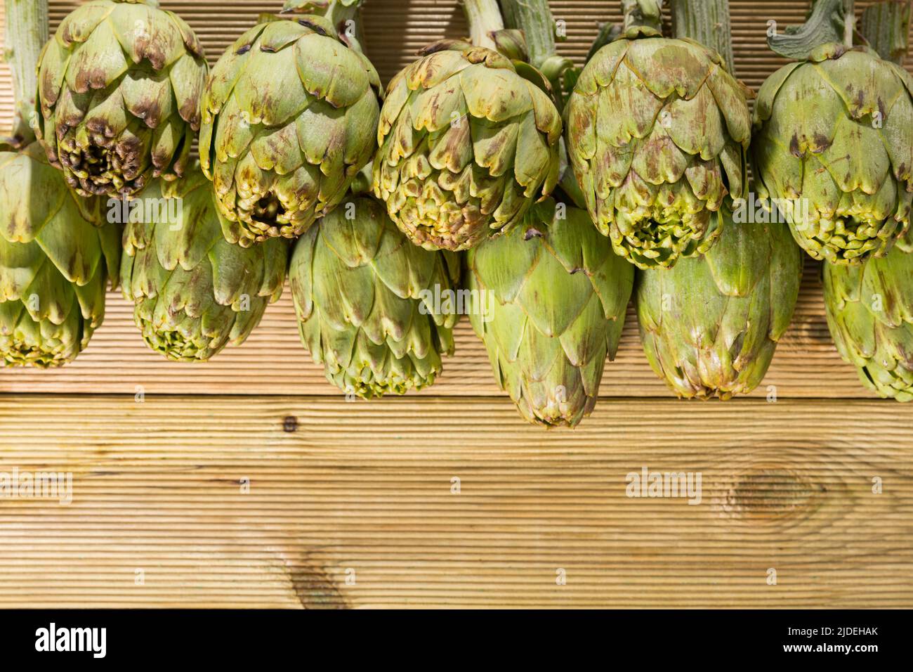 Artichokes on wooden table Stock Photo - Alamy