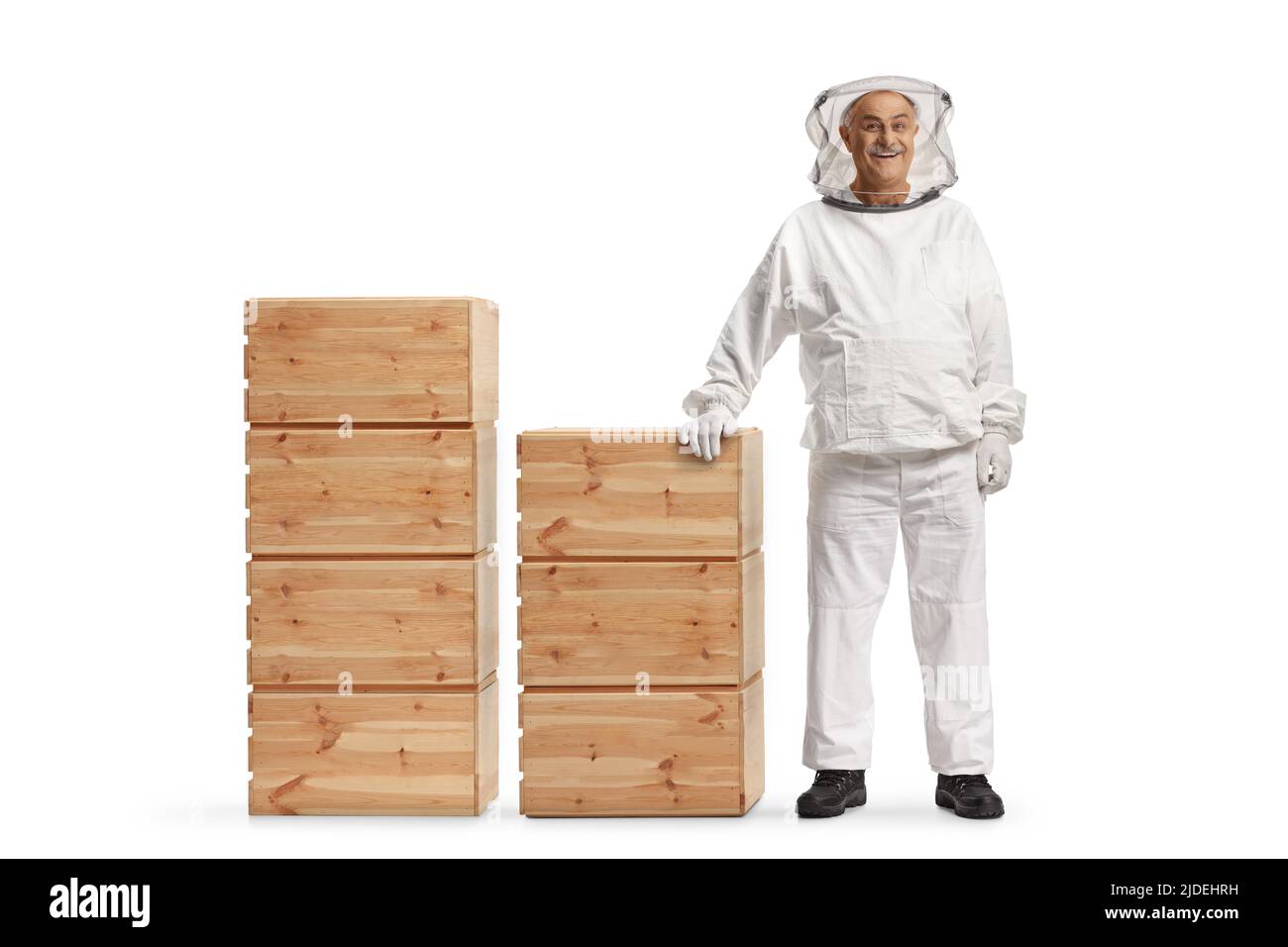 Full length portrait of a bee keeper standing with wooden boxes ...