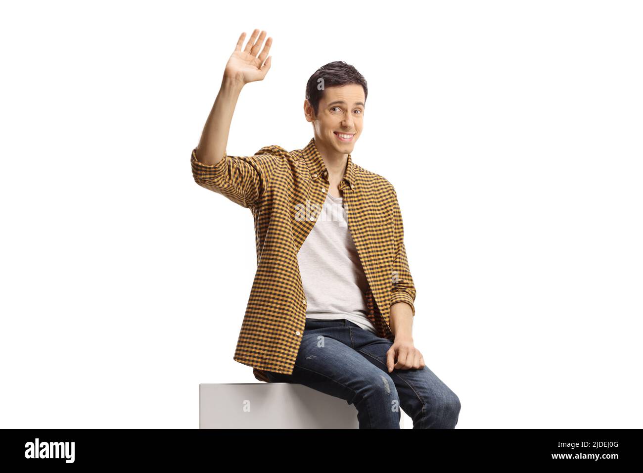 Young man sitting on a white column and waving isolated on white ...