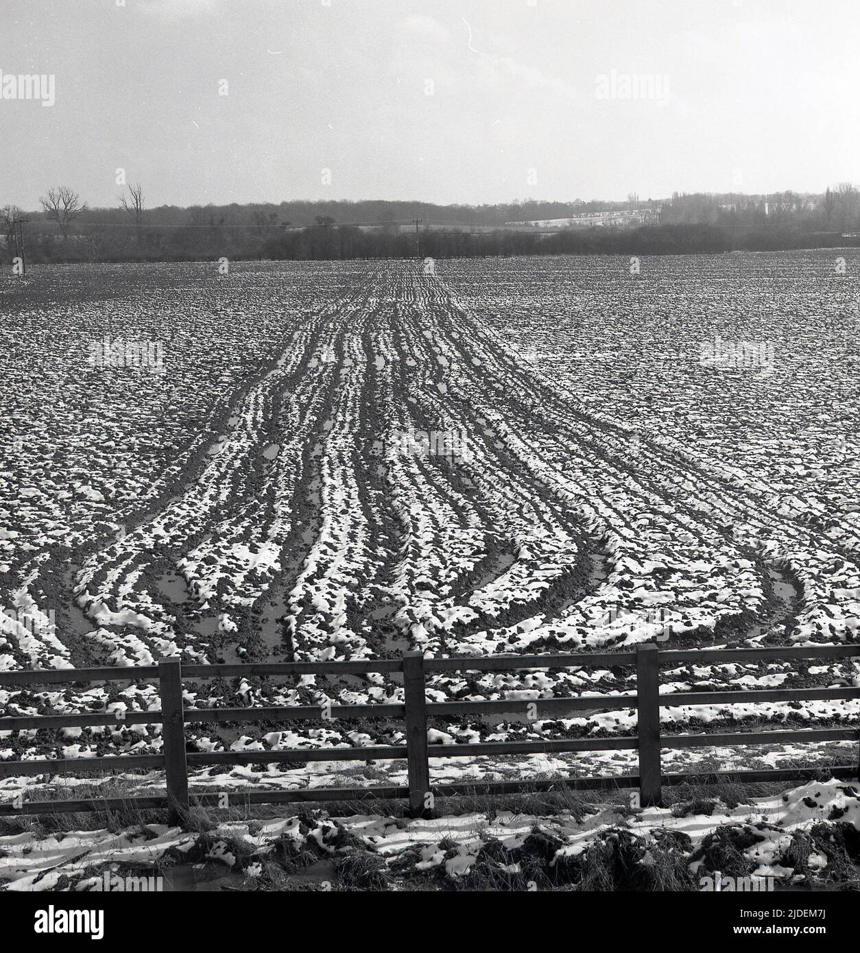 1960s, historical, winter time and on a farm a view across a snow ...