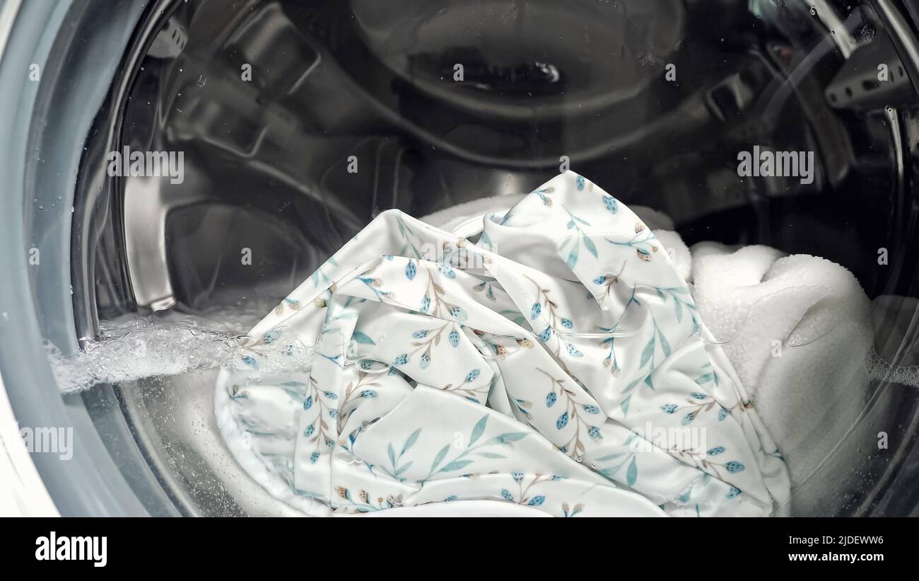White laundry in washing machine with water and foam Stock Photo - Alamy