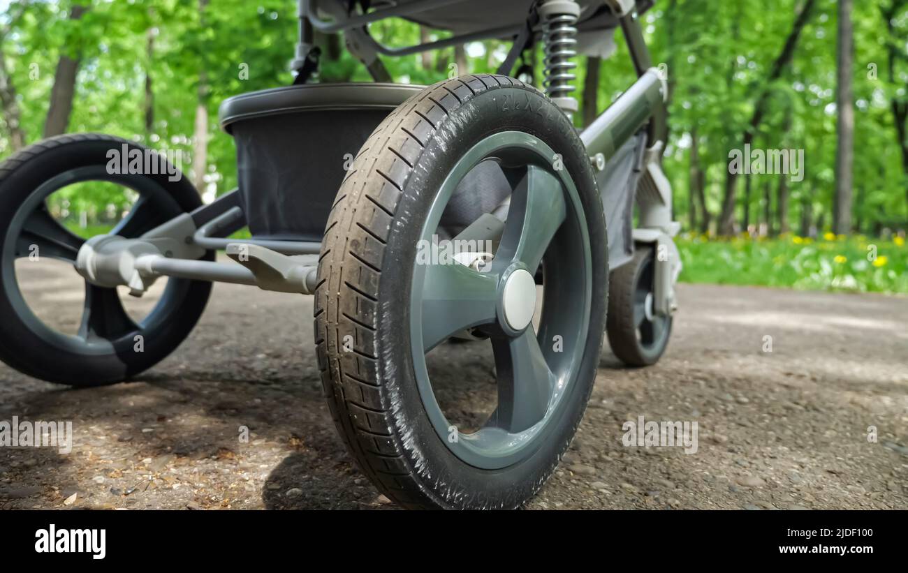 Baby stroller rides back and forth in park on pavement Stock Photo - Alamy
