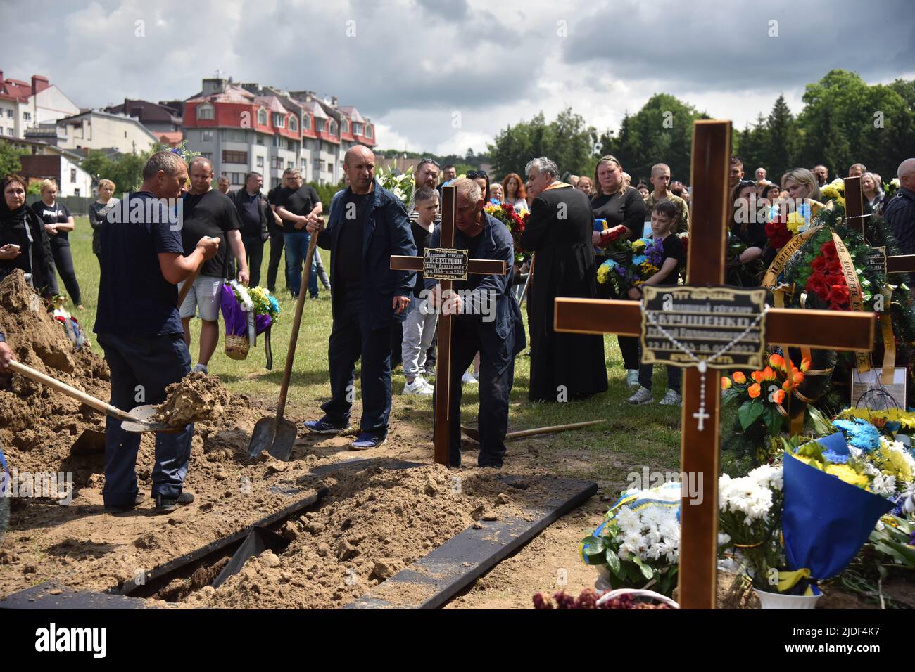 Lviv, Ukraine. 17th June, 2022. Funeral service worker places a cross ...