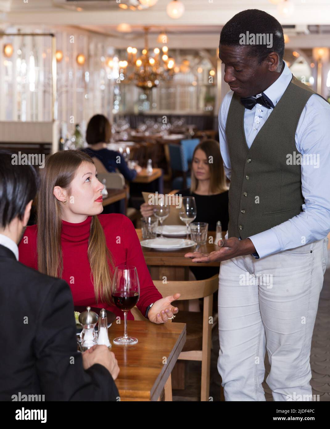 African American waiter talking with couple Stock Photo - Alamy