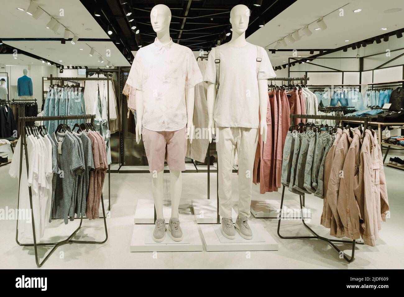 Two mannequins in empty modern fashionable mass market clothing store ...