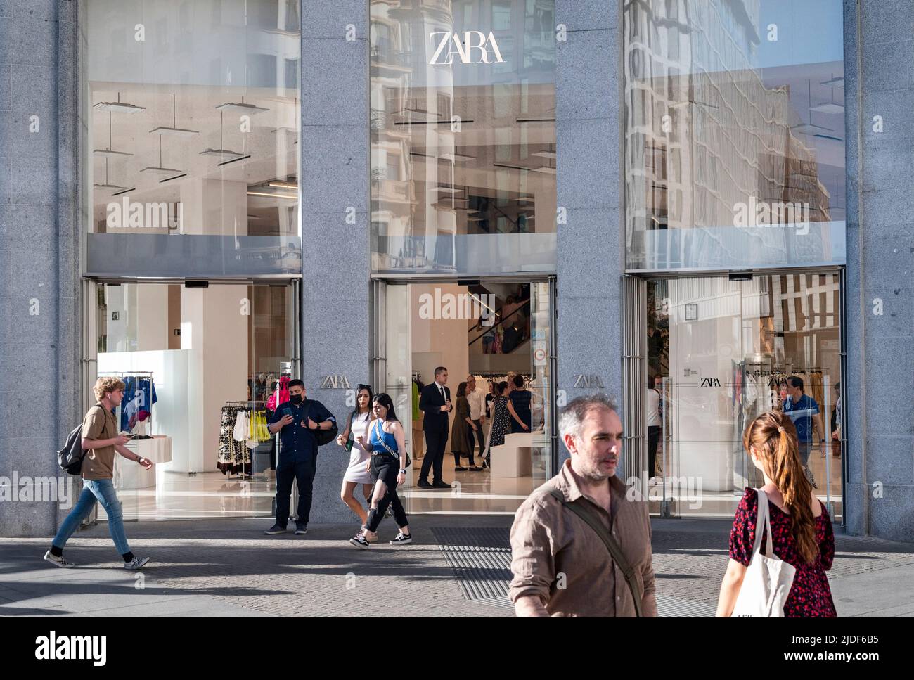 Pedestrians walk past the Spanish multinational clothing design retail ...