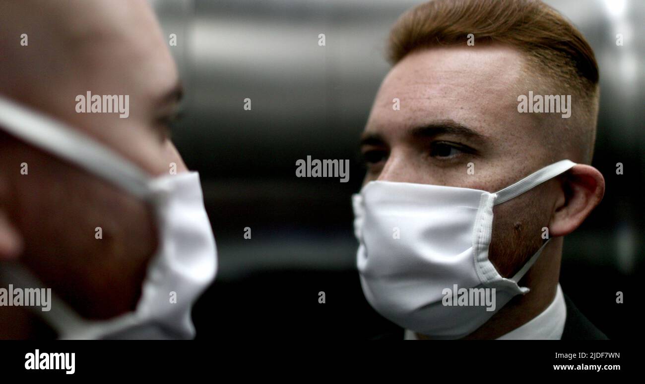 Business man wearing face mask inside elevator mirror during commute ...